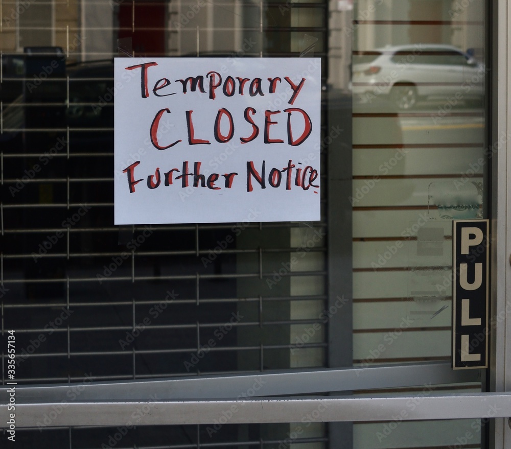 Handwritten sign reading Temporary Closed Further Notice on a glass ...