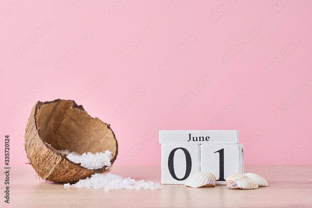 Wooden block calendar with date June 1 and coconut with sea salt on the ...