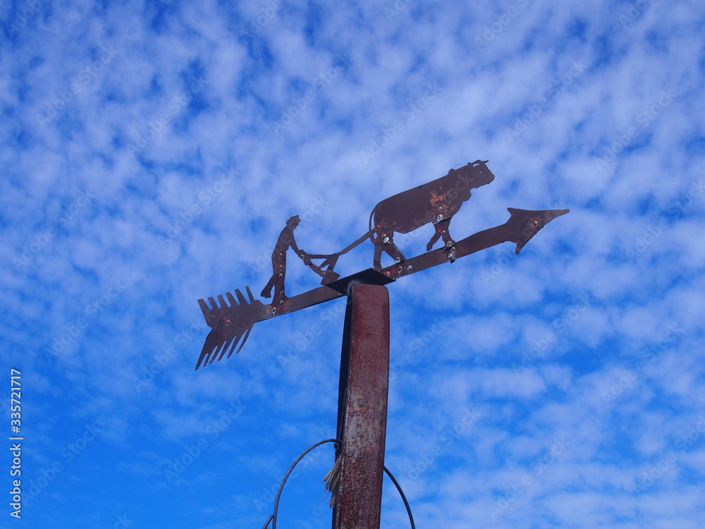 Weathercocks made of iron with altocumulus white cloud on the blue sky ...