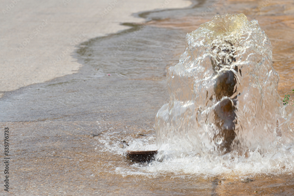 Water pipe break .Exposing a burst water main, focused on the spraying ...