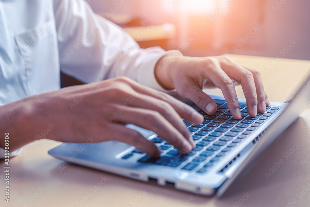 Businessman hand typing on computer keyboard of a laptop computer in ...