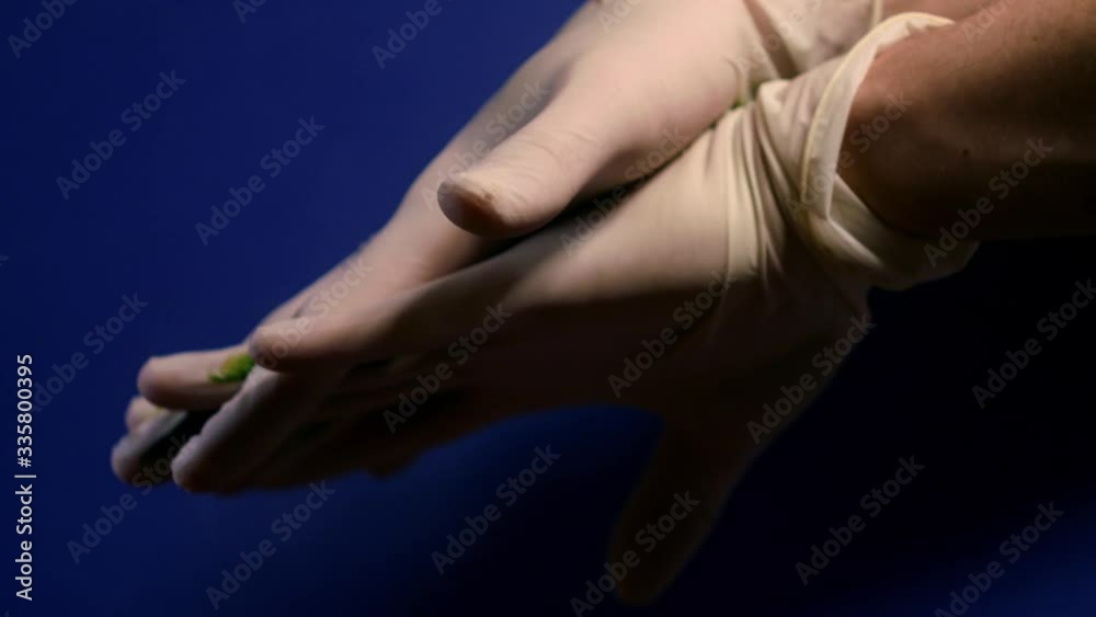 Man in rubber gloves show how to wash hands properly. Use color paint ...
