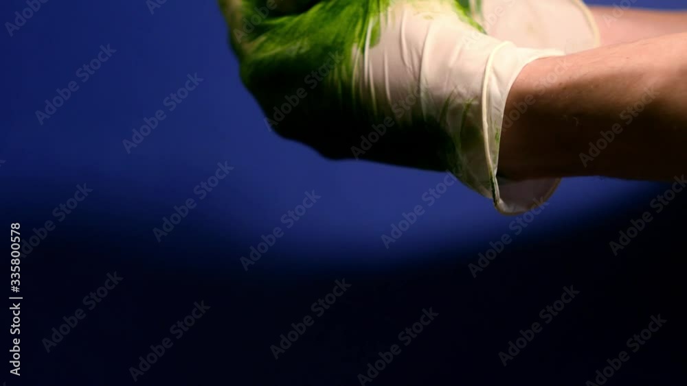 Man in rubber gloves show how to wash hands properly. Use color paint ...