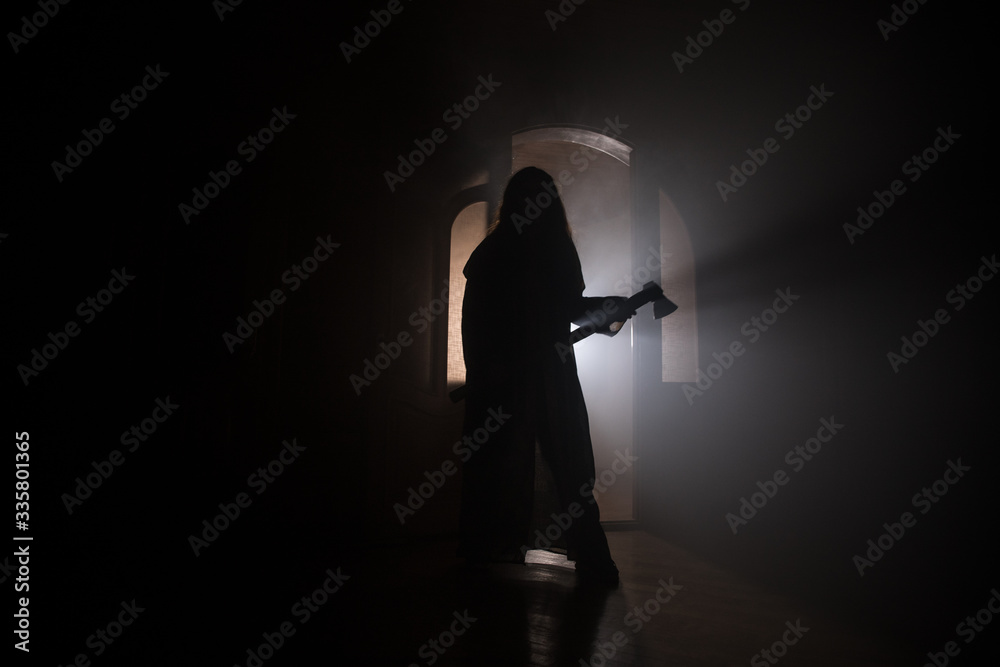 Silhouette of an unknown shadow figure on a door through a closed glass ...