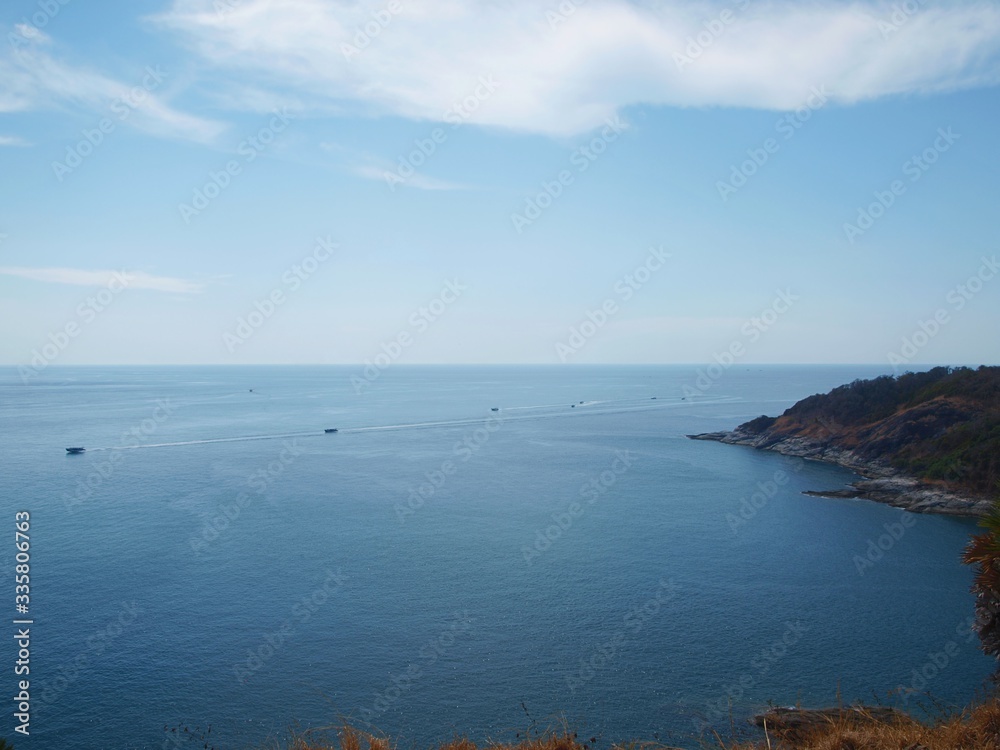 Open sea, horizon, rocky coast and boats rushing on the water surface ...