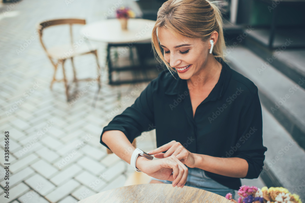 Happy millennial girl in electronic headphones using bluetooth ...