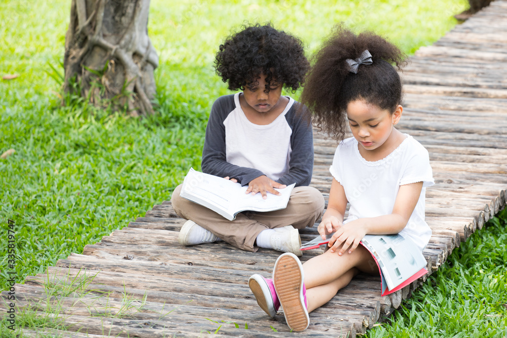 Kids reading a book in summer garden. Children study. Boy and girl play ...