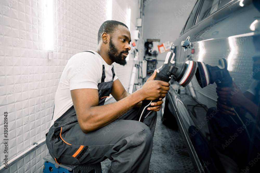 Auto detailing service, polishing of the car. Side view of young ...