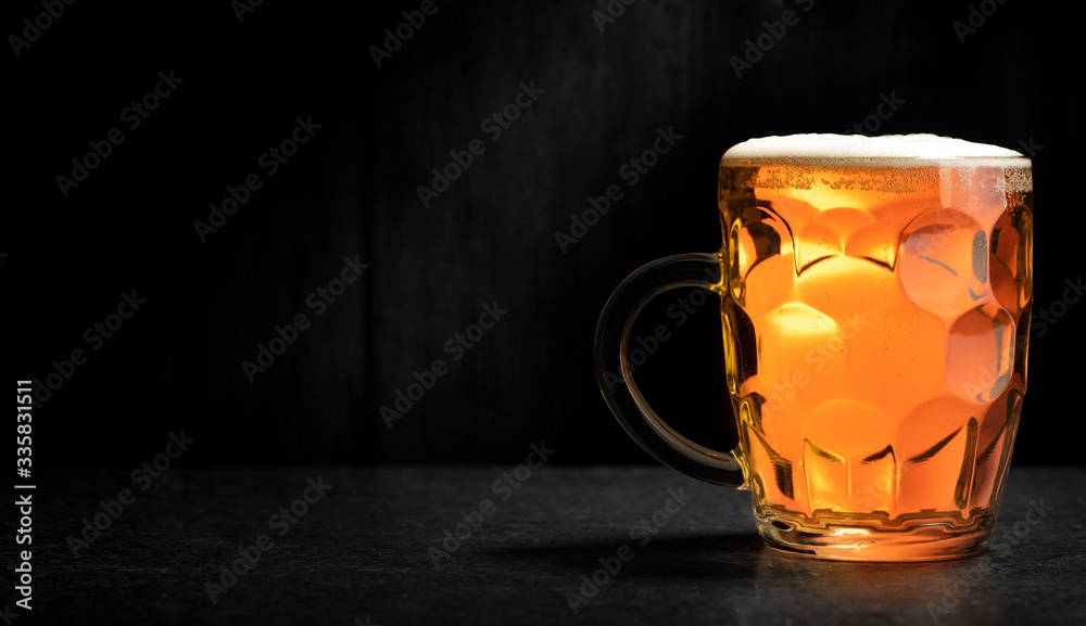Beer in a mug. A light beer with foam in a mug, a beautifully lit stage ...
