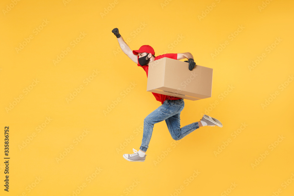 Fun jumping delivery man in red cap t-shirt uniform sterile face mask ...