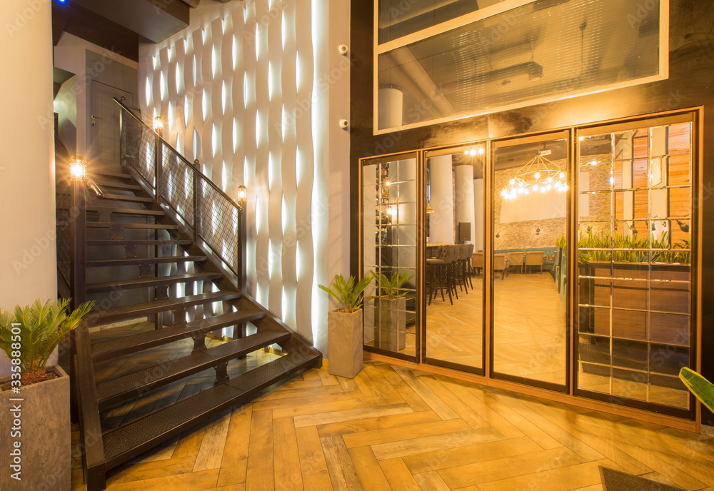 Loft style hall of luxury restaurant with stairs up to second floor ...