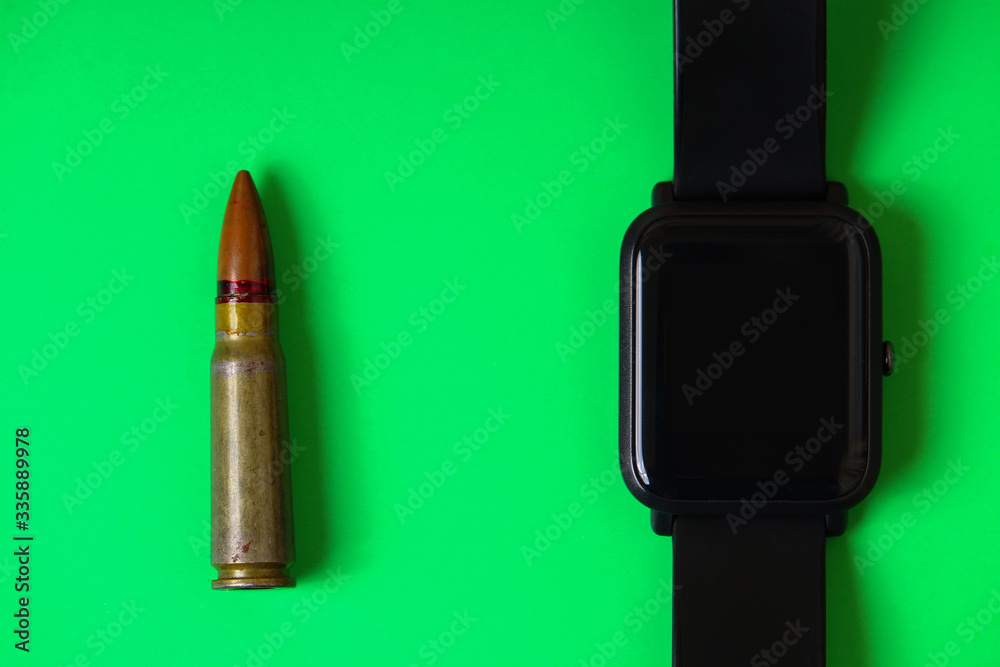Military bullet on a blurry green background with a smart watch Stock ...