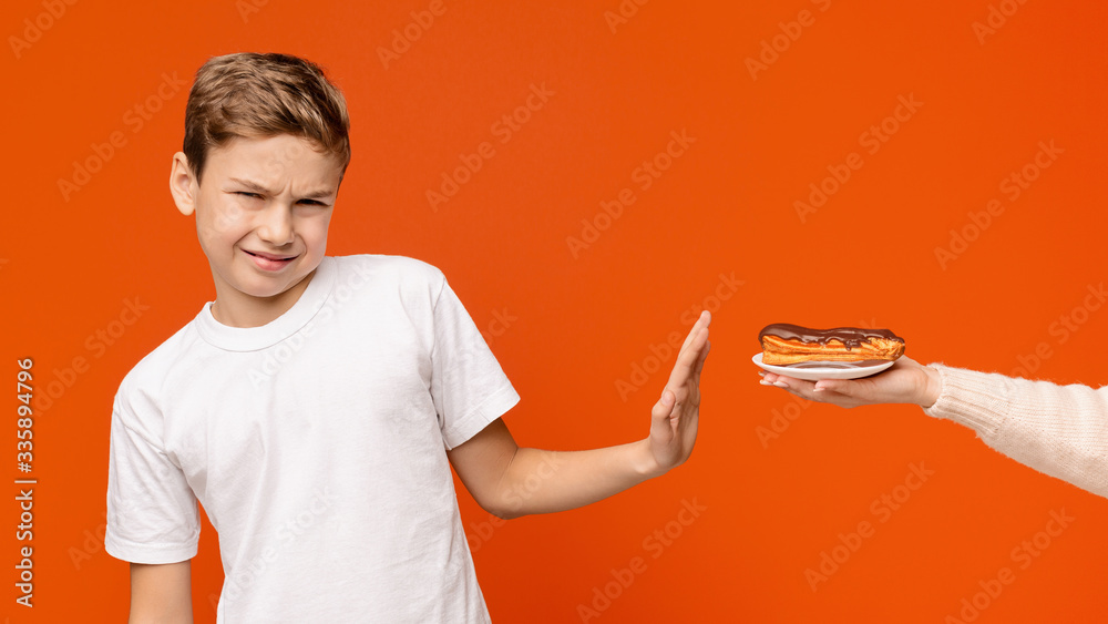 Teen boy feeling disgust, refusing chocolate donut Stock Photo | Adobe ...