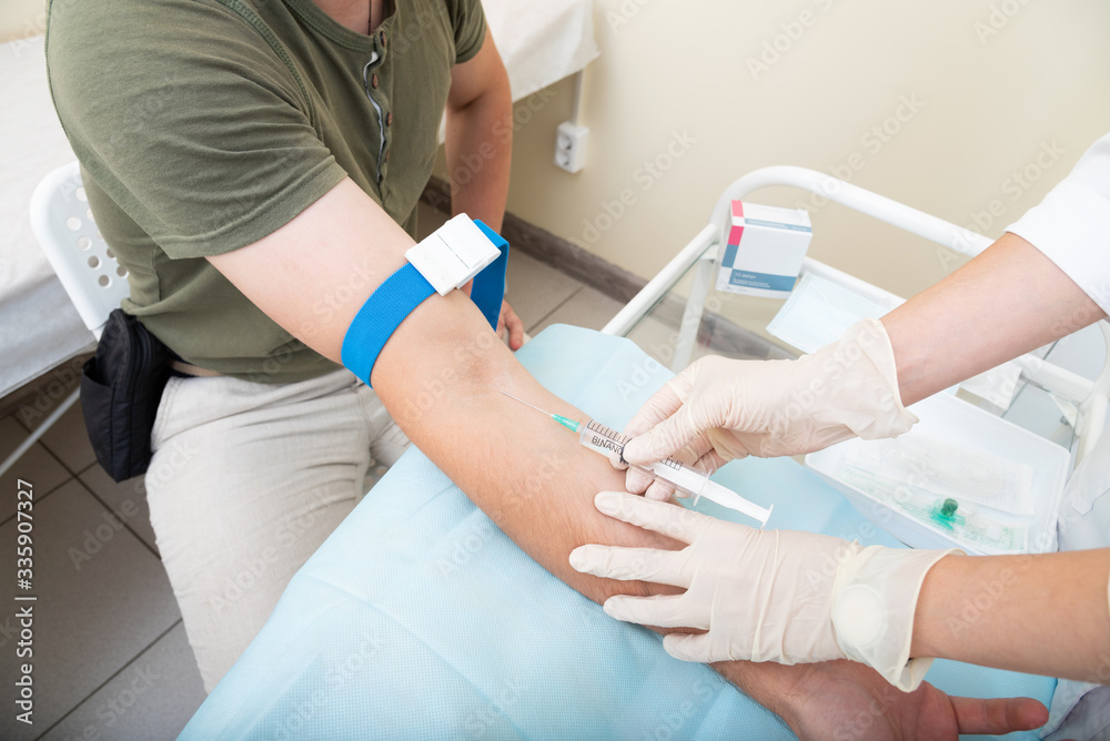 the nurse hand is going to loosening a tourniquet during the injection ...