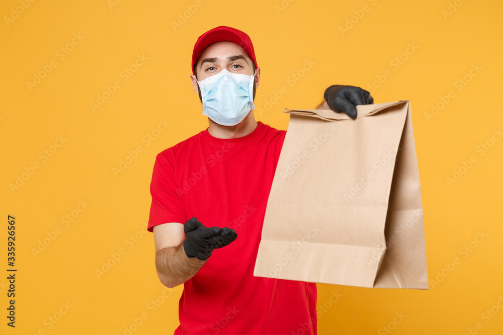 Delivery man employee in red cap blank t-shirt uniform mask glove hold ...