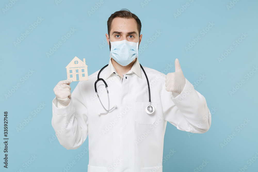 Doctor man in medical gown face mask gloves isolated on blue background ...