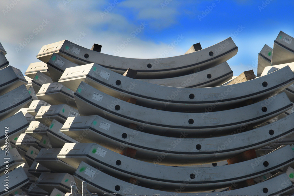Pile of underground tunnel segments with blue sky background. The ...
