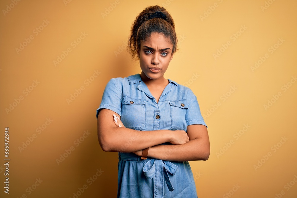 Young beautiful african american girl wearing denim dress standing over ...