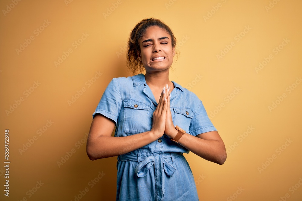 Young beautiful african american girl wearing denim dress standing over ...