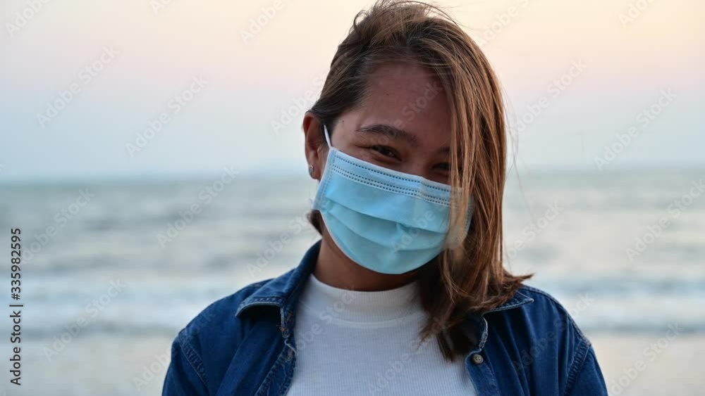 young woman wearing a hygiene protective mask over her face outdoor ...