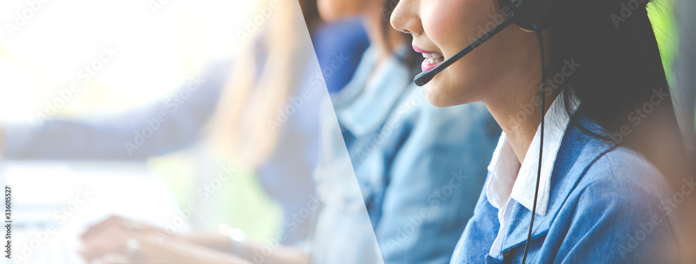 Attractive business woman Asian in suits and headsets are smiling while ...