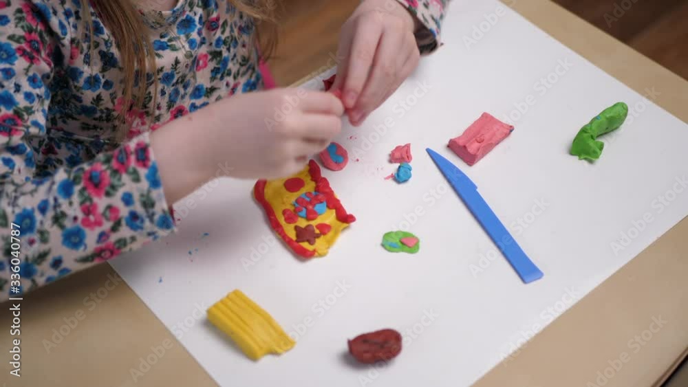 View from above child's hands sculpt model of blood vessel with ...
