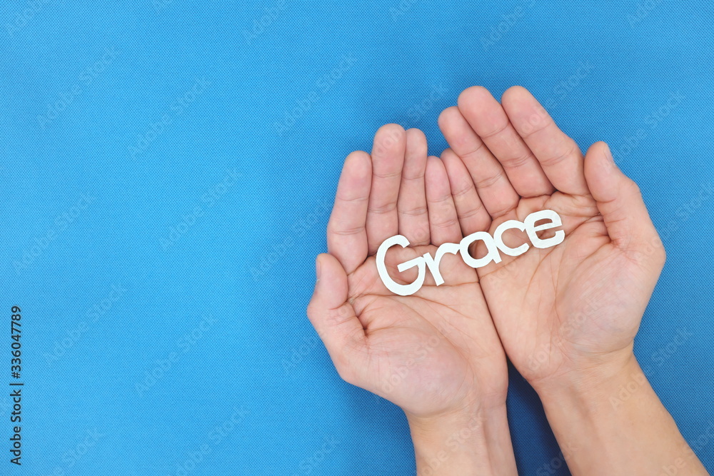 Male hands praying for grace from God in blue background. Top view with ...