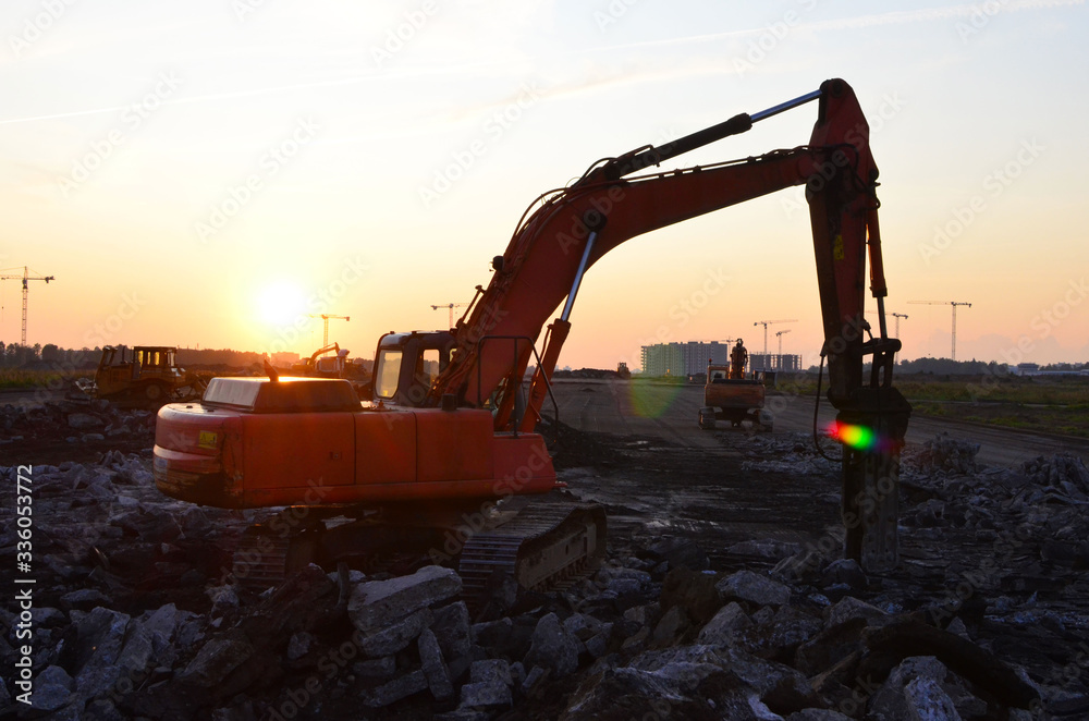 Excavator with hydraulic breaker hammer at construction site ...