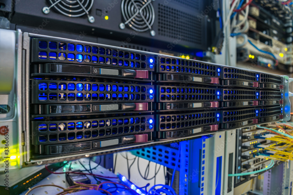 A modern computer server with many hard drives is a close-up. Powerful ...