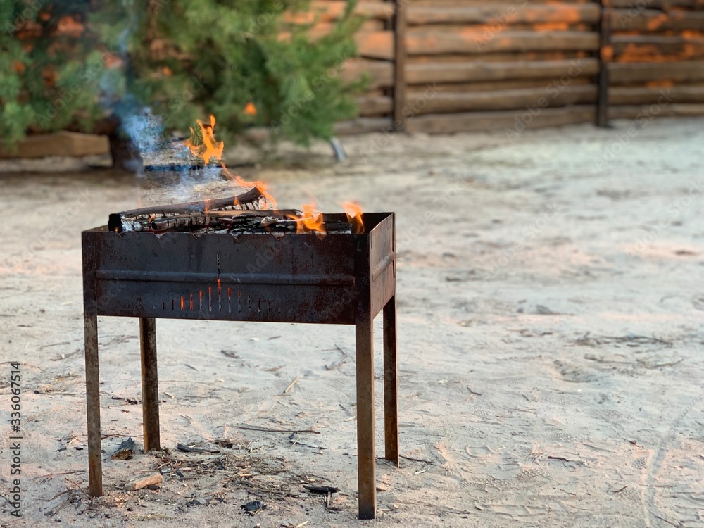 Hot grill during a picnic in the yard. Metallic roaster with coal, in ...