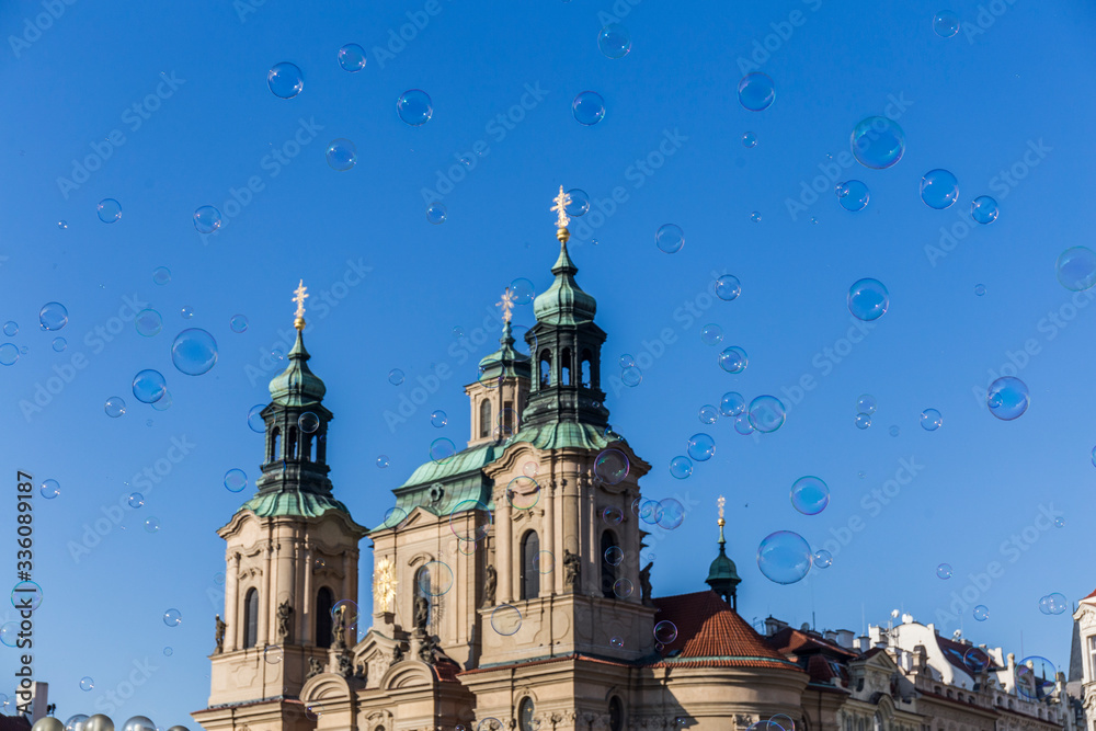 Hundreds of bubbles fly in the sky around a historic Prague building ...