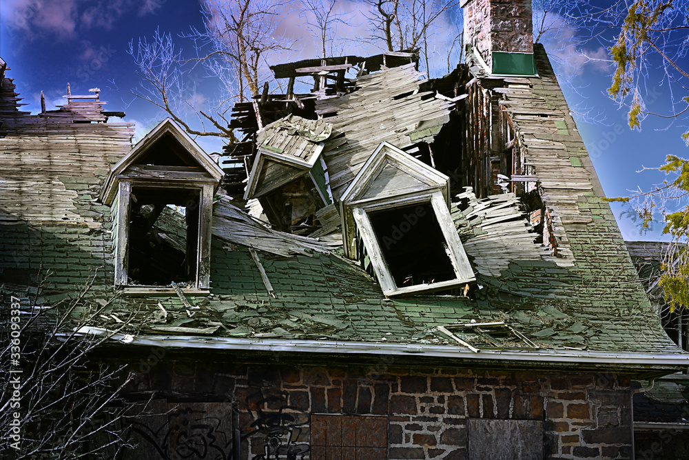 Old abandoned stone house with dormers and a collapsed roof and ...
