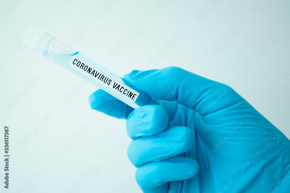 scientist holding test tube with covid-19 or coronavirus vaccine label ...