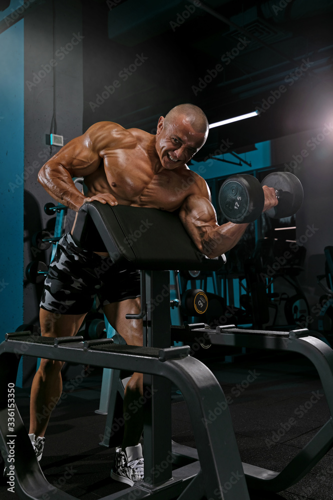 Man doing biceps exercise on scott bench with dumbbell Stock Photo ...