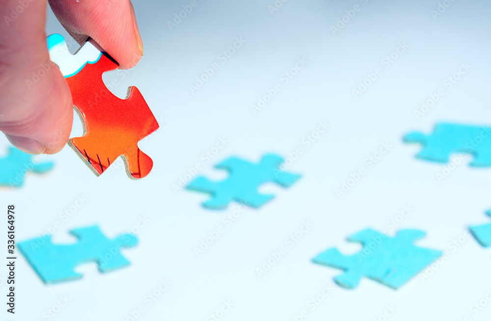 On a white background puzzles inside out. One red puzzle is held by ...