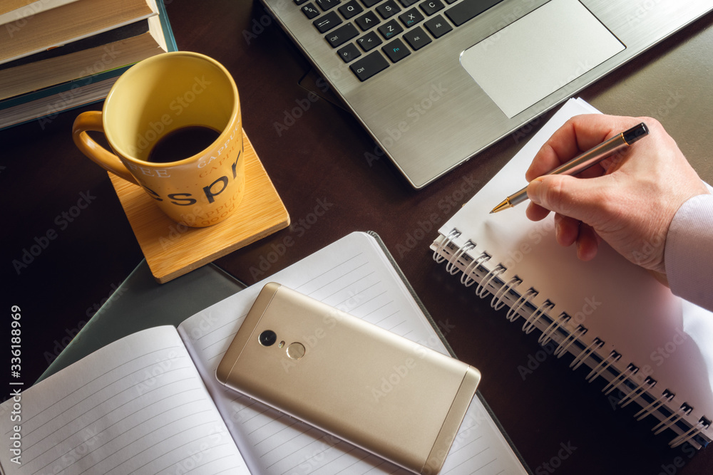 Desk table with laptop, smartphone and a man's hand taking notes Stock ...