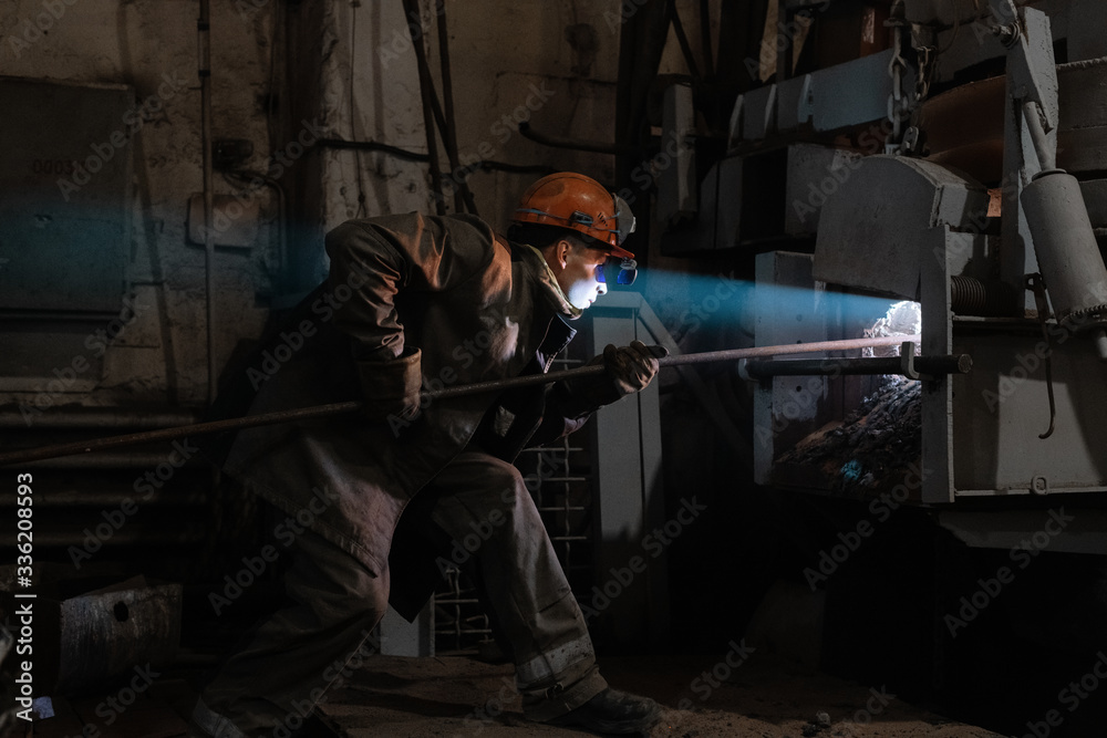 Factory worker putting bar inside furnace Stock Photo | Adobe Stock