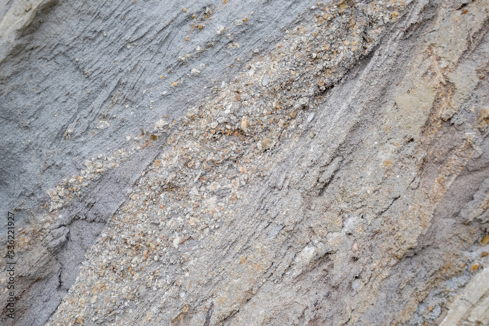 sedimentary layers of the rock in the sand scree. sand, pebbles and ...