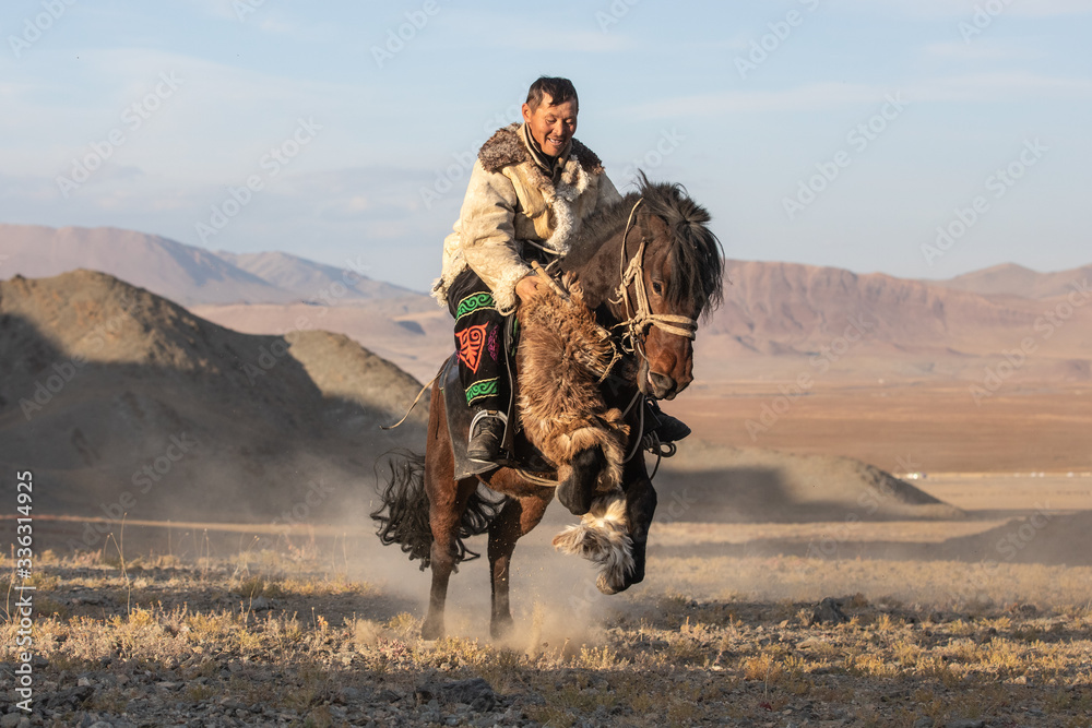 Kazakh eagle hunter after winning a traditional wrestling match. Two ...