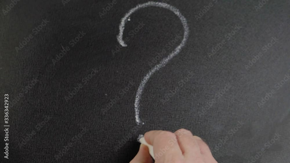 Question mark. Man hand writes the Question mark by chalk on a ...