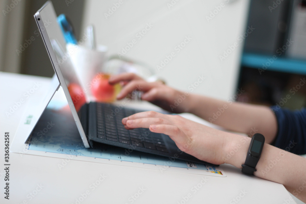 Typing hands of a schoolboy and laptop close-up. Boys hands using and ...