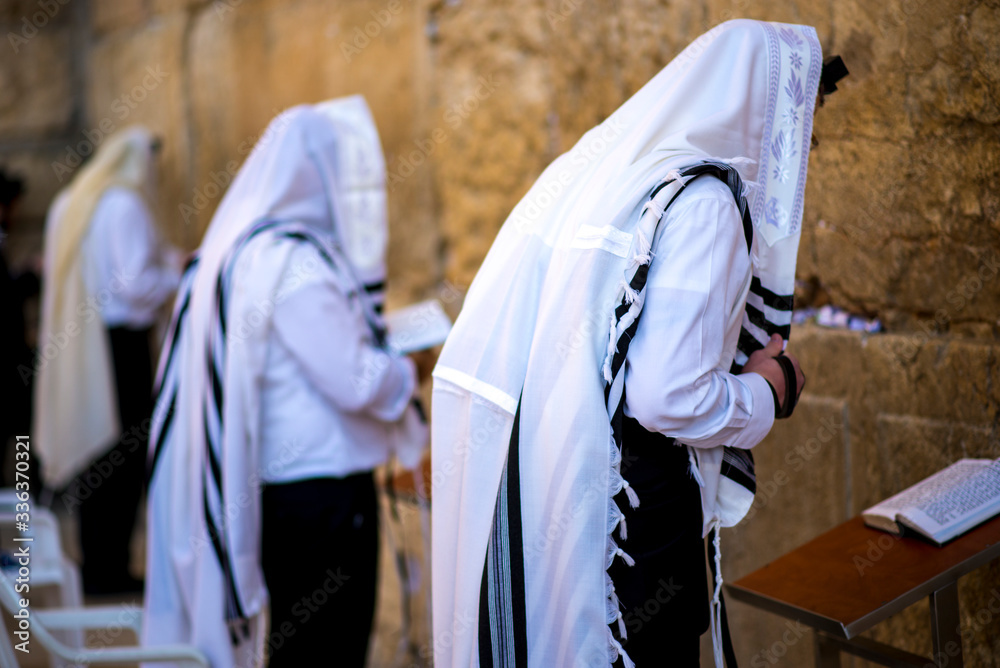 Orthodox Jews praying at the Western Wall, wearing the tallit prayer ...