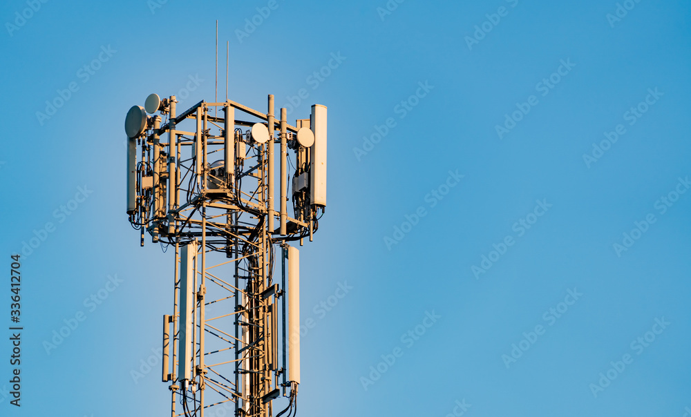 Communications, cell, mobile tower in UK set against a bright blue sky ...