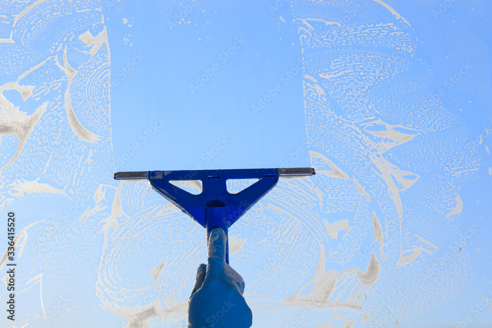 housekeeping: cleaning the windows, Window cleaner using a squeegee ...