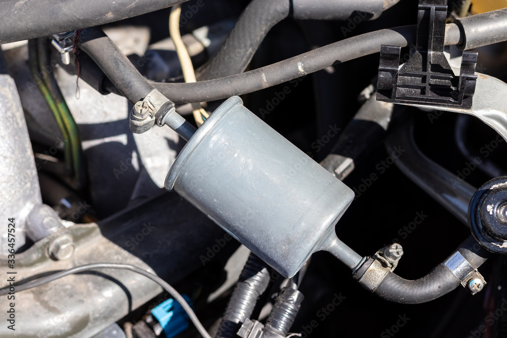 Fuel filter installed in a car with a fuel line connected to it under ...