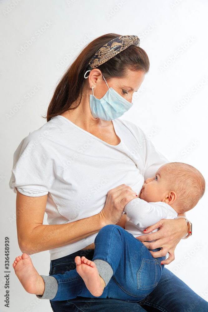 Breastfeeding mother wearing a mask on white background Stock Photo ...