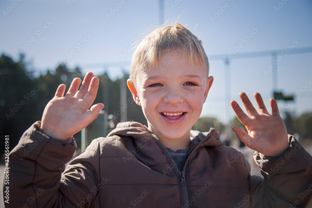 Closeup portrait of a happy beautiful young boy smiling happily. He is ...