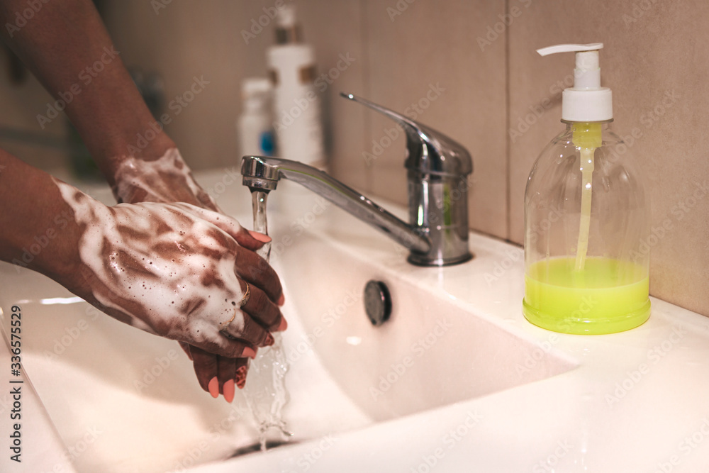 African-American woman washes hands. Cropped image of person washing ...