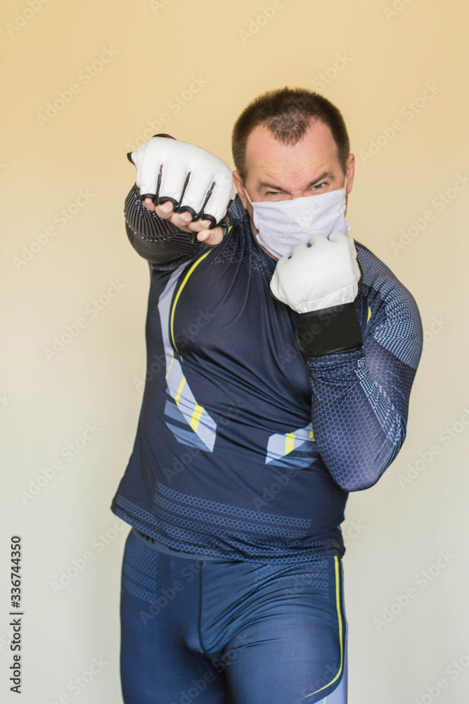 Strong young man boxing with a shadow in a mask on his face during a ...