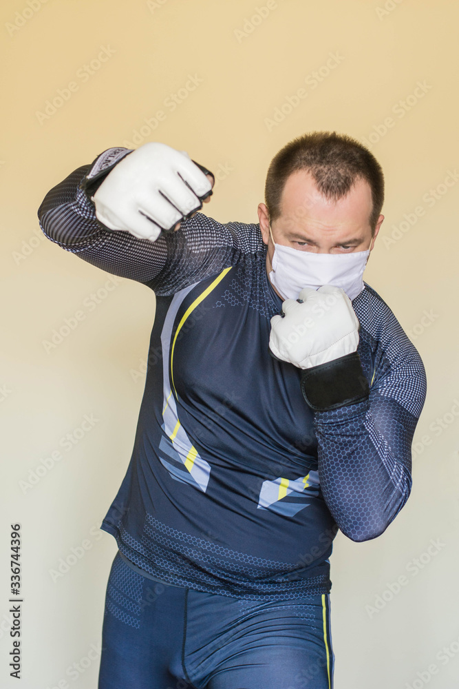Strong young man boxing with a shadow in a mask on his face during a ...